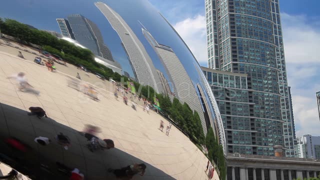 Time lapse of tourists exploring Millennium Park in the reflection of ...