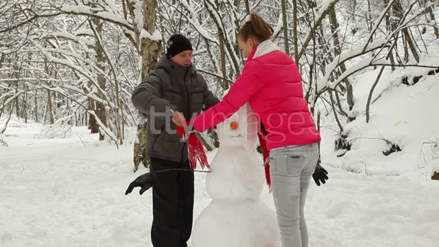 Young Couple Building Snowman In Winter Forest 동영상 (VID_2136470) - 게티이미지뱅크