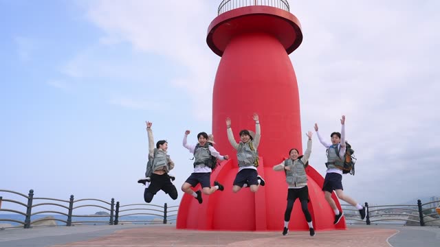 National trek - People jumping with hurrah in front of lighthouse by ...