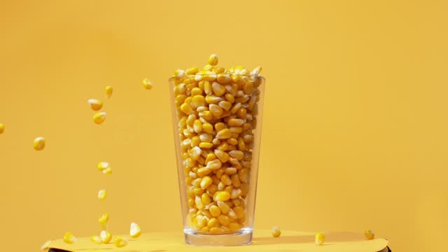 Studio high speed shooting - Corn grain falling in turning drinking ...
