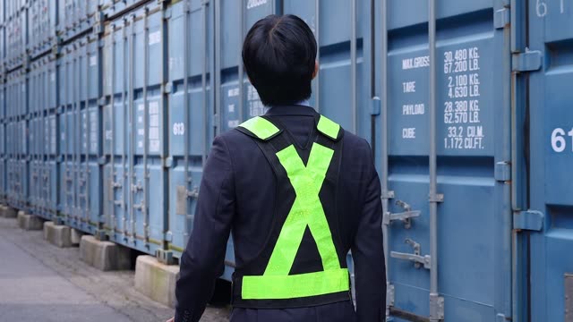 Business Logistics - Man wearing suit, safety vest and checking ...