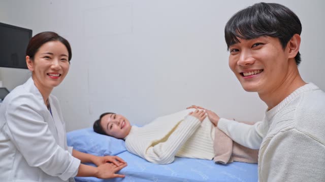 Hospital of Korea - Parturient woman, husband and doctor looking at ...