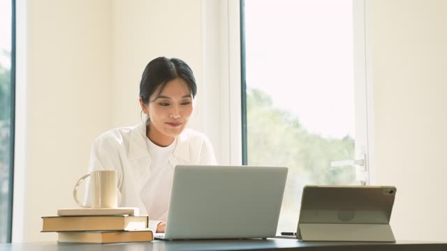 Woman using laptop at desk / South Korea 회원제 무료동영상 (JKR240330) - 게티이미지뱅크