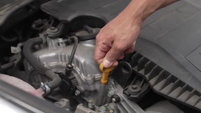 Car Maintenance - Checking engine oil gage in bonnet outside of car ...