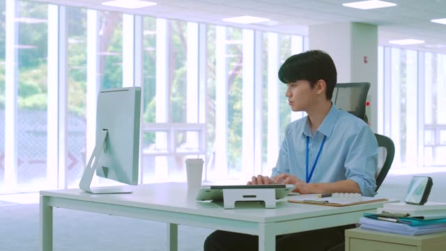 White collar - Man sitting at desk in empty office rubbing his eyes and ...