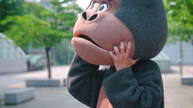 Exhausted male mascot performer removing costume head for short break ...