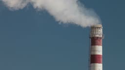 Industrial smokestack with billowing white smoke being pumped into the ...