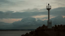 Scenery of sunset, sea, breakwater, lighthouse and cloud in winter ...
